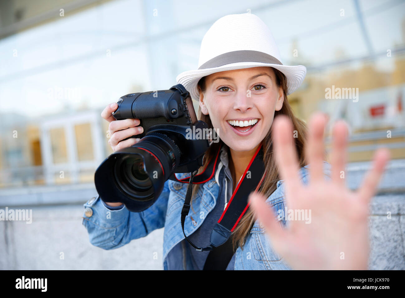 Cheerful photographer showing hand towards camera Stock Photo - Alamy