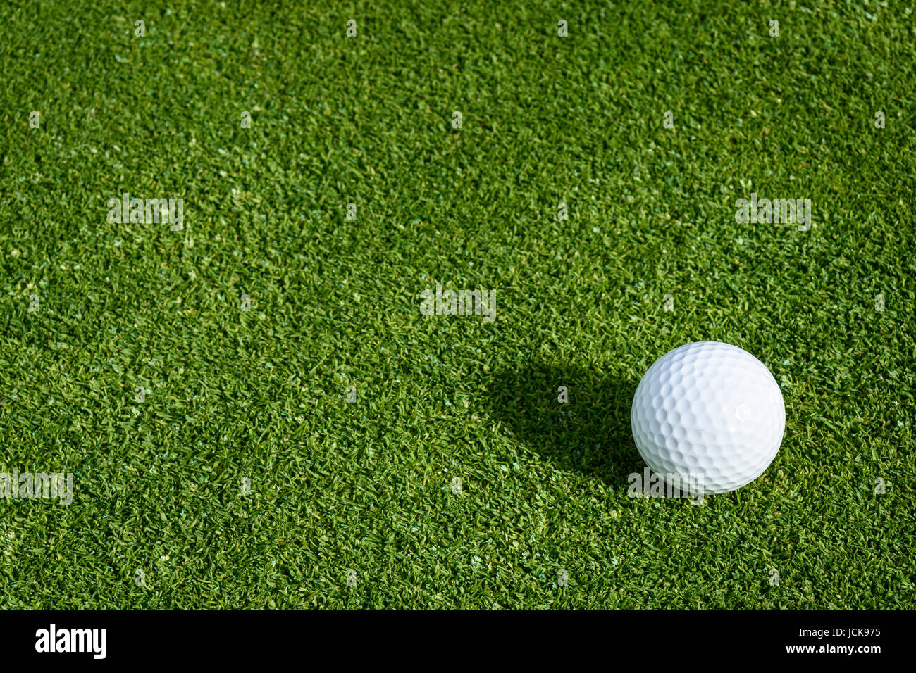 Side view of golf ball on a putting green Stock Photo - Alamy