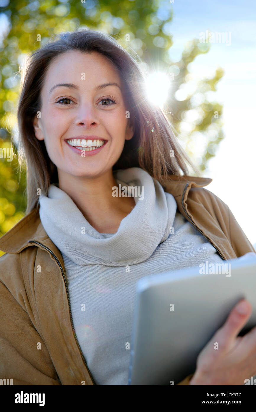 Beautiful girl using digital tablet outside Stock Photo - Alamy