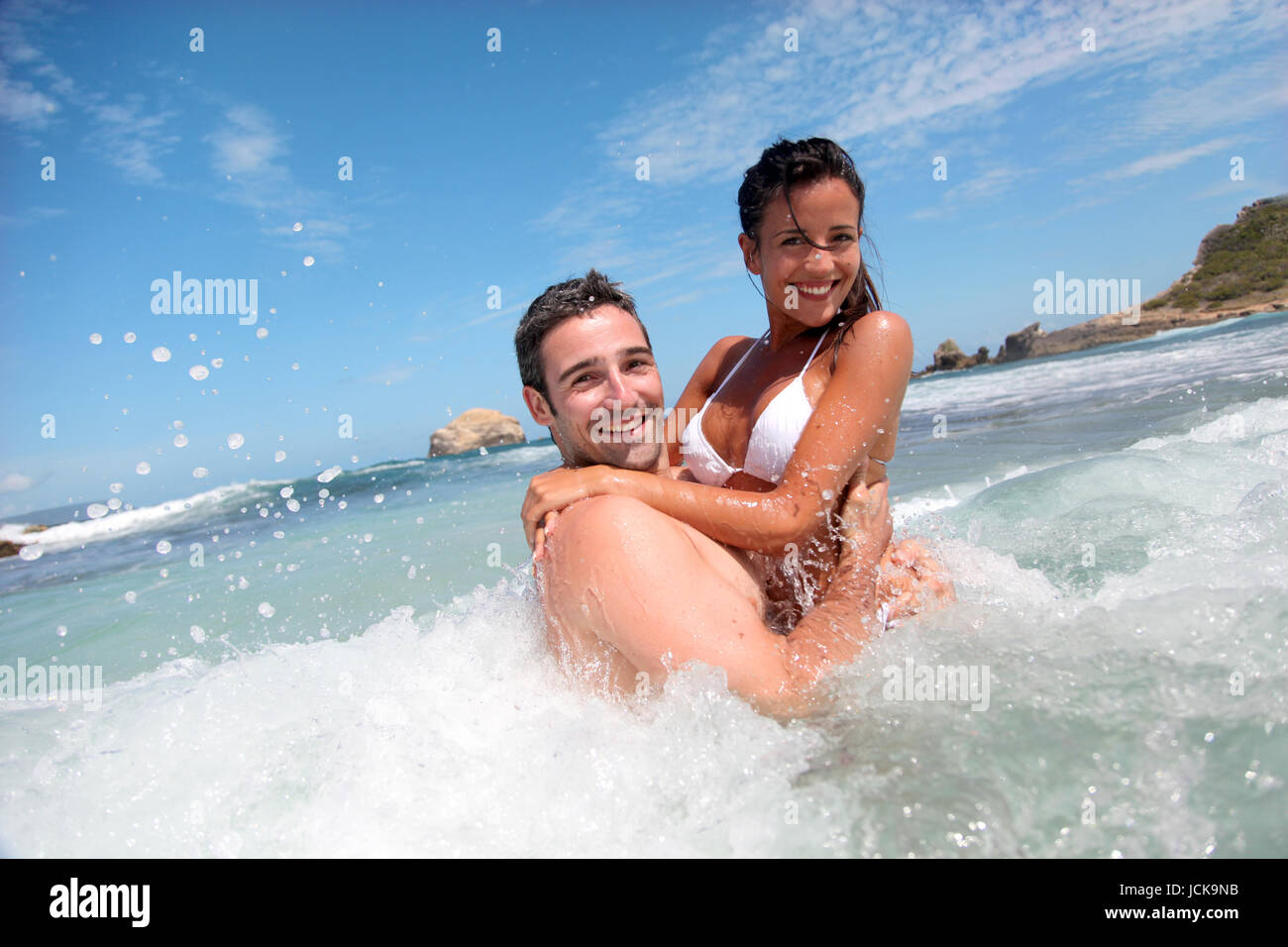 Cheerful couple enjoying the waves Stock Photo - Alamy