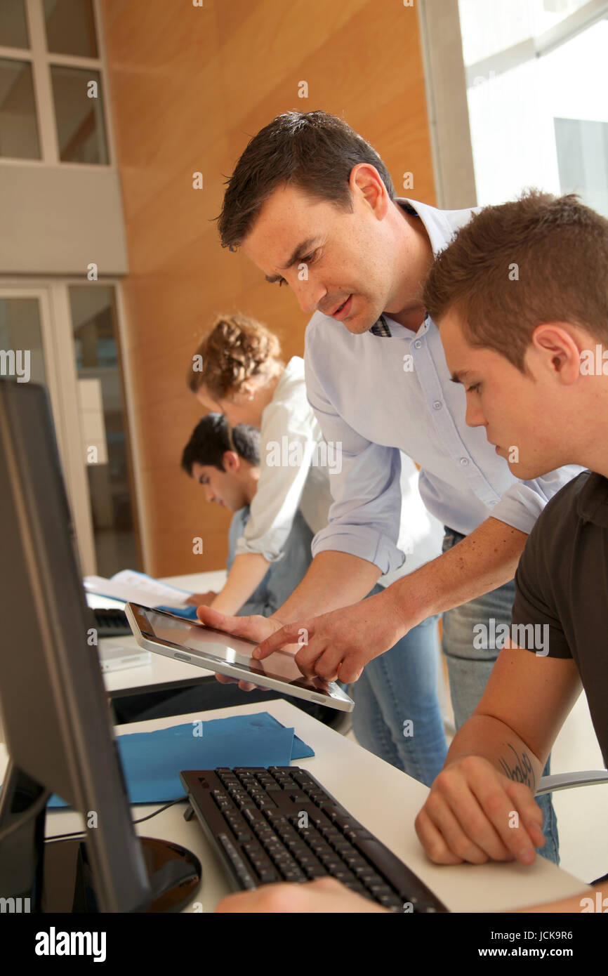 Educator helping student in training class Stock Photo - Alamy
