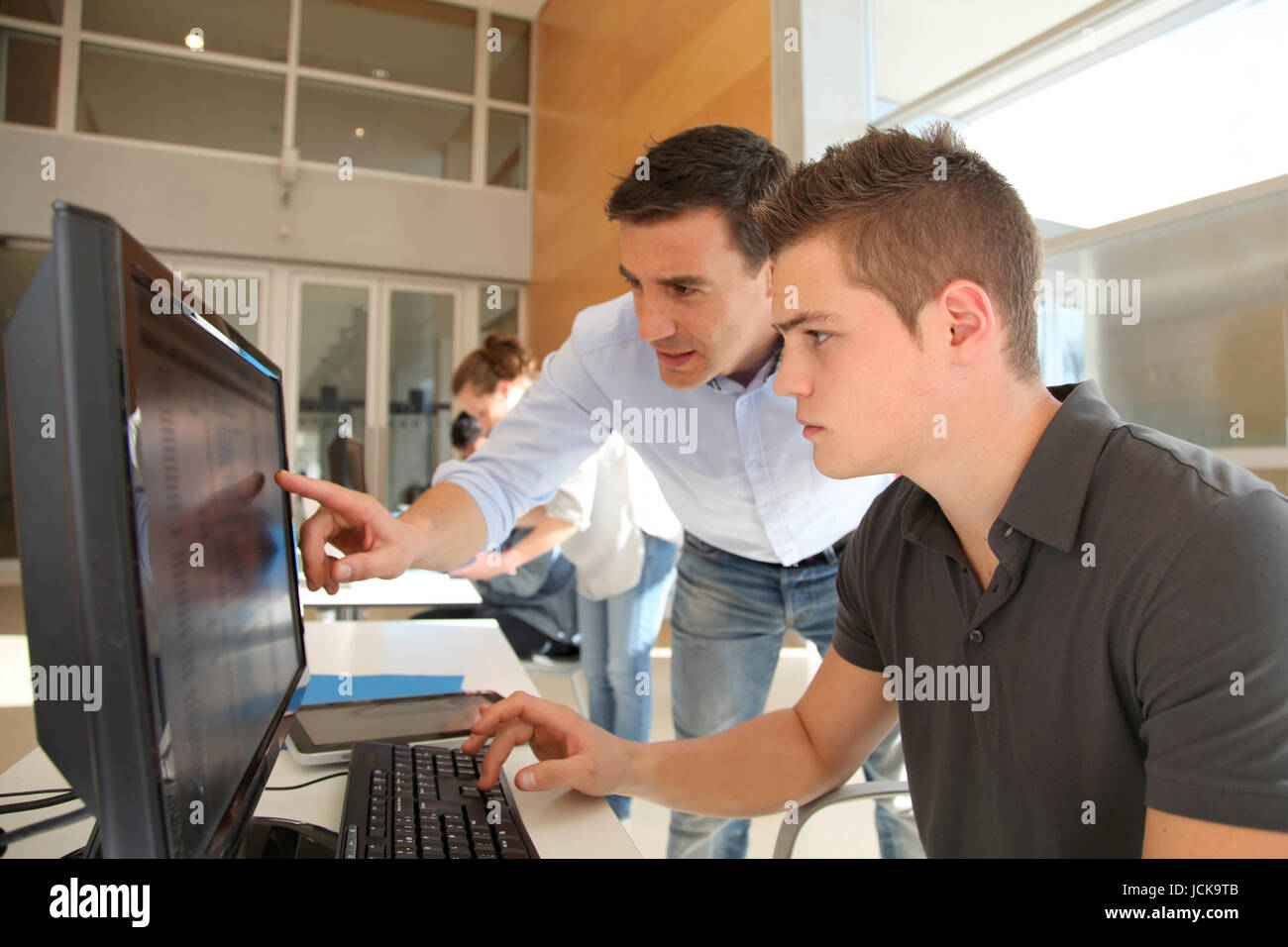 Teacher and student working on computer Stock Photo - Alamy