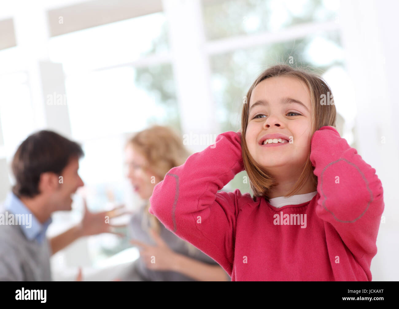 Child hiding her ears from parent's fight Stock Photo - Alamy
