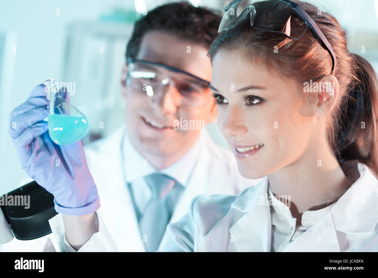 Chemical laboratory. Attractive young PhD student and her post doctoral ...