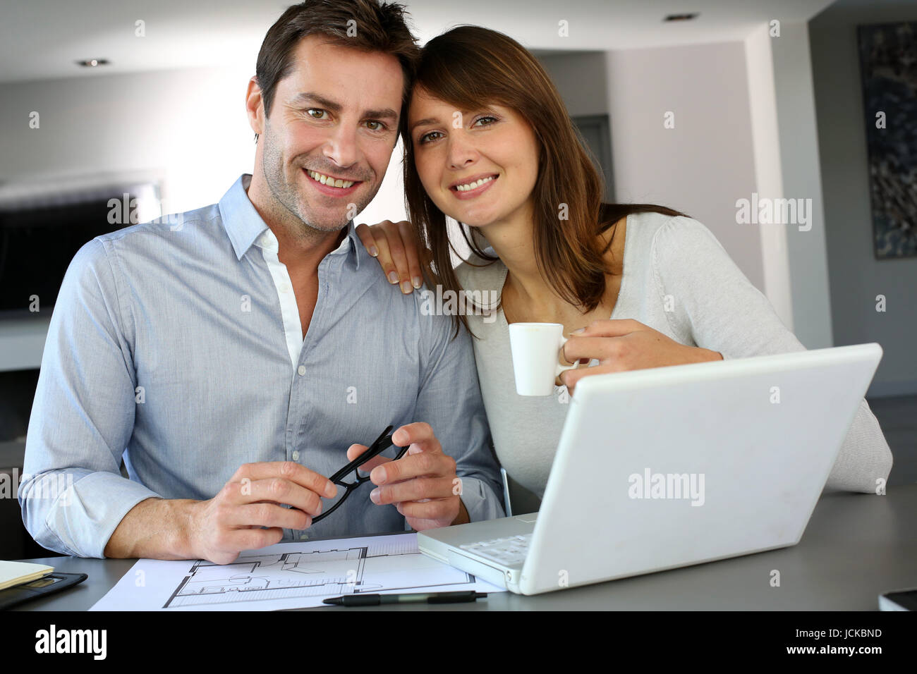Couple at home looking at future home blueprint Stock Photo - Alamy