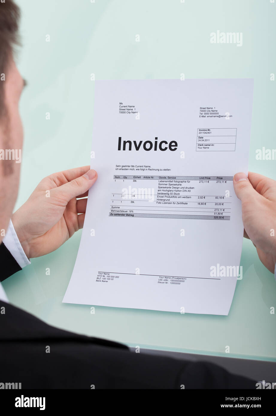 Cropped image of young businessman reading invoice at office desk Stock ...