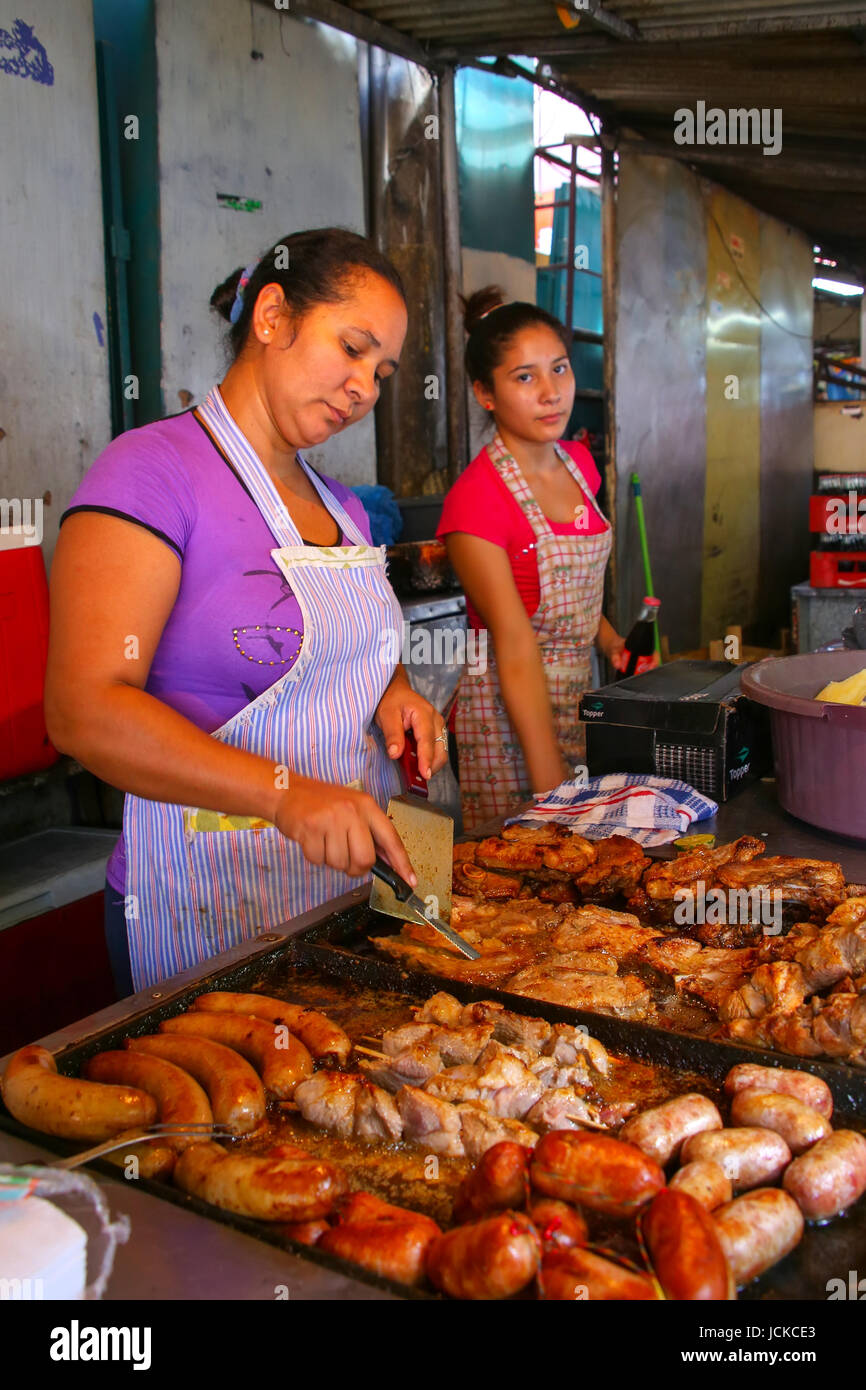 Local women cooking meat for asado at Mercado 4 in Asuncion, Paraguay ...