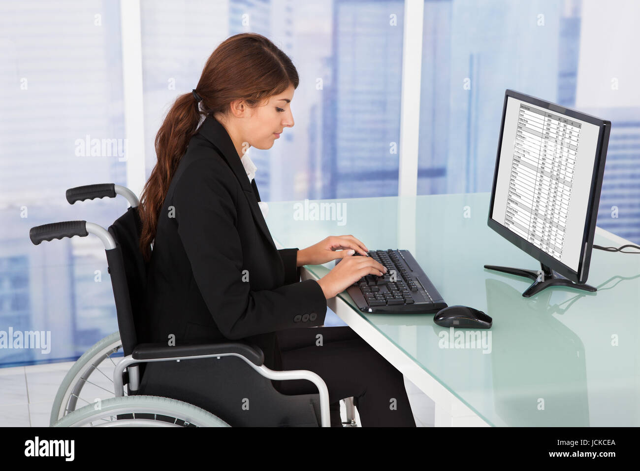 Side view portrait of handicapped businesswoman using computer while ...