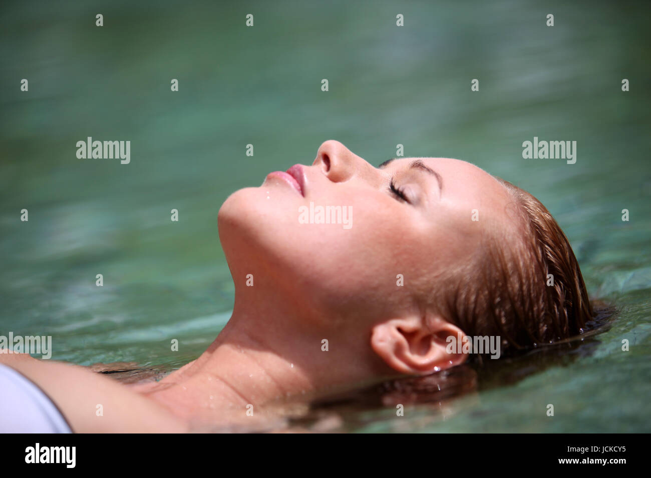 Woman floating in swimming pool Stock Photo - Alamy
