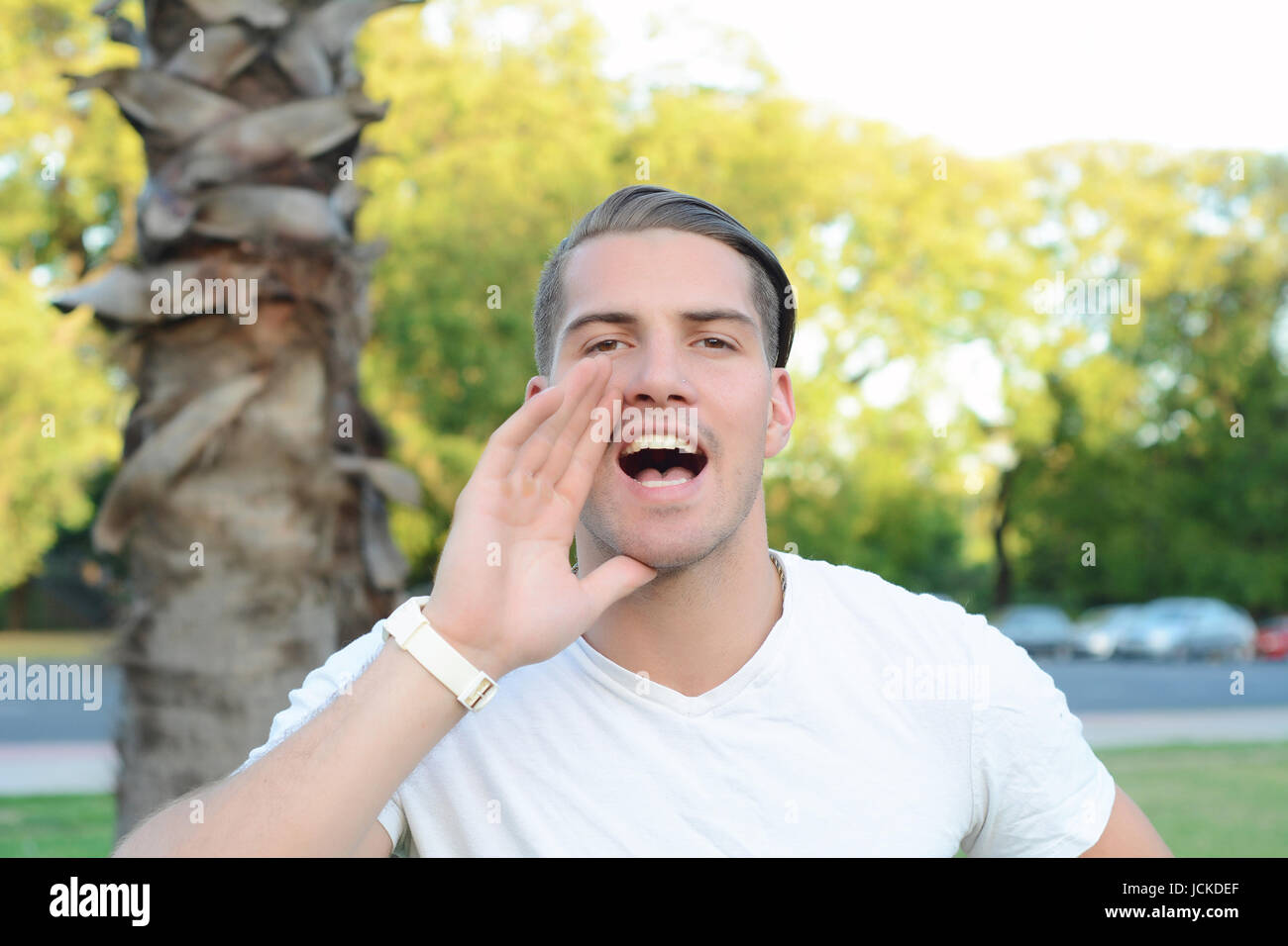 Portrait of a young handsome man shouting at the park. Outdoors Stock ...