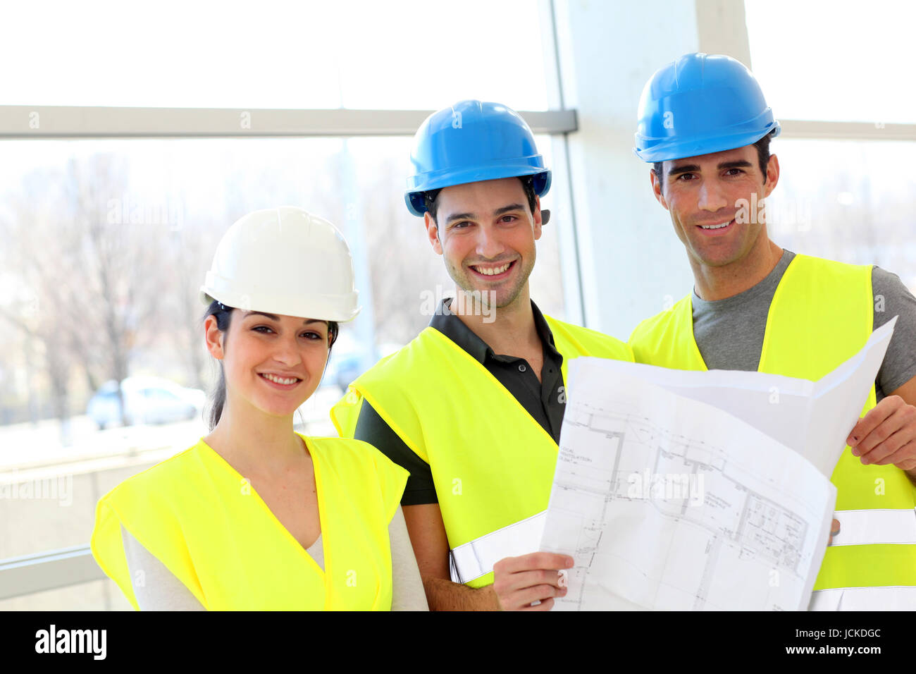 Construction workers looking at building plan Stock Photo - Alamy