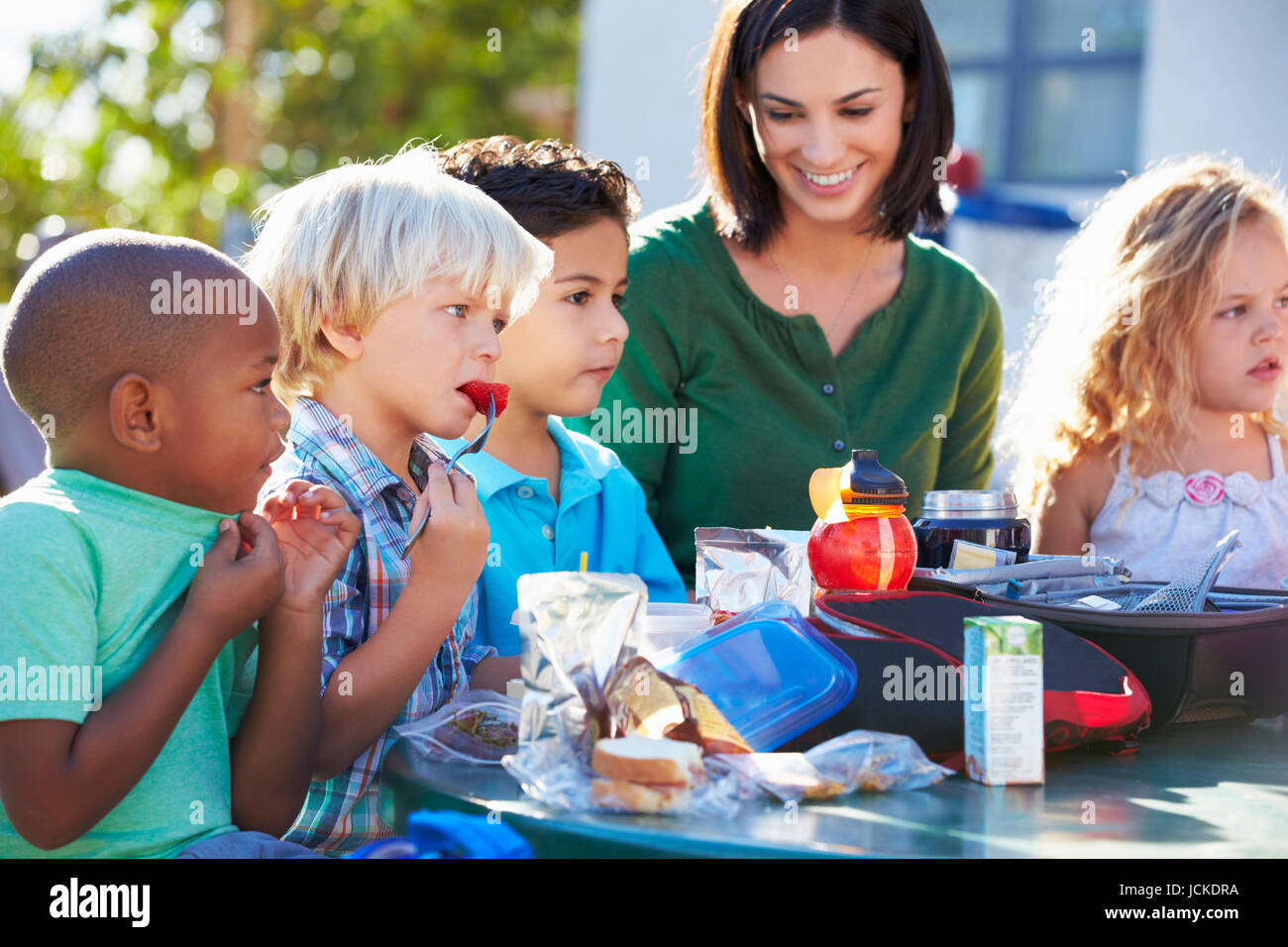 Elementary Pupils And Teacher Eating Lunch Stock Photo - Alamy
