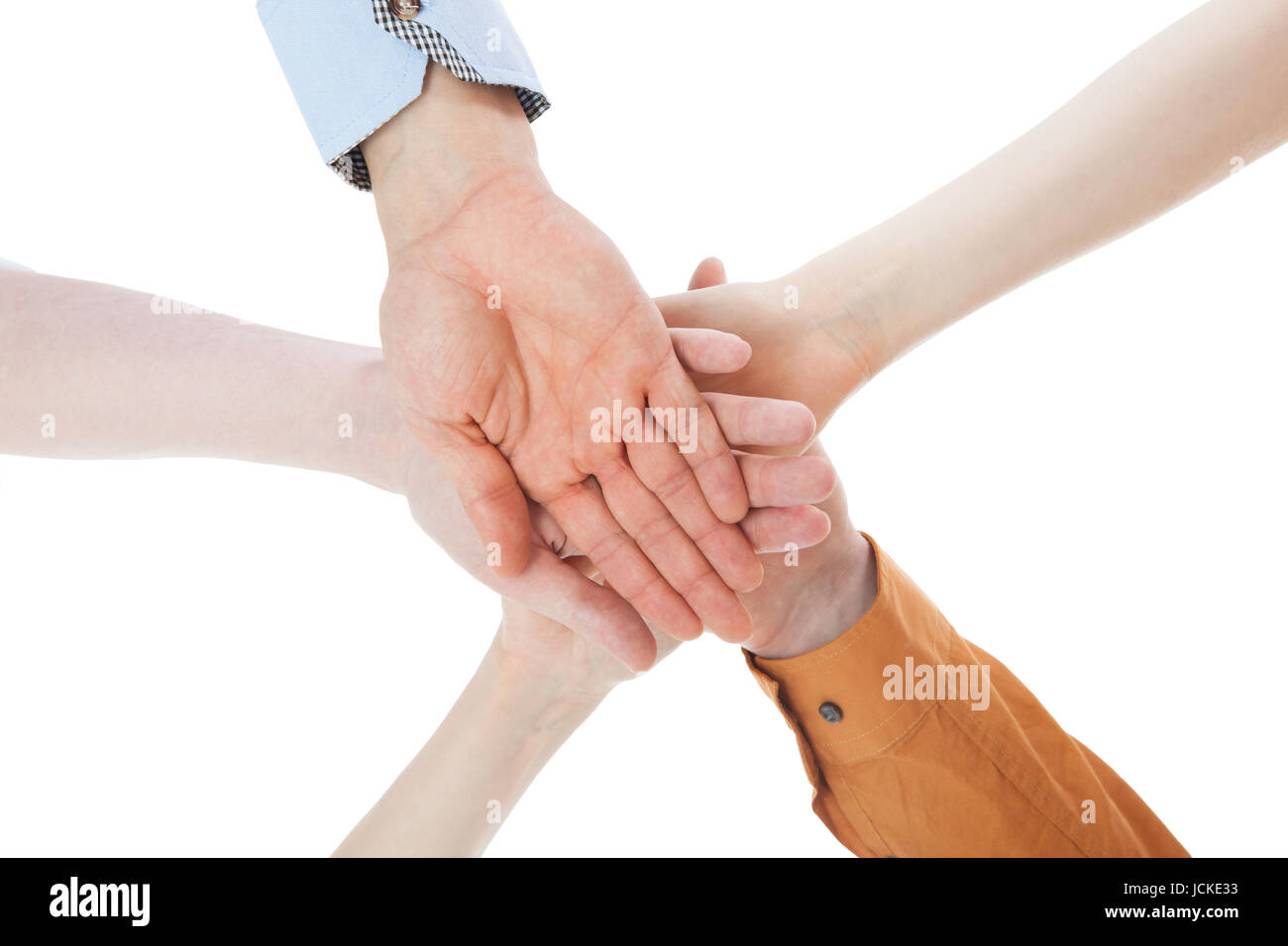 Closeup of young friends with their hands stacked together on white ...