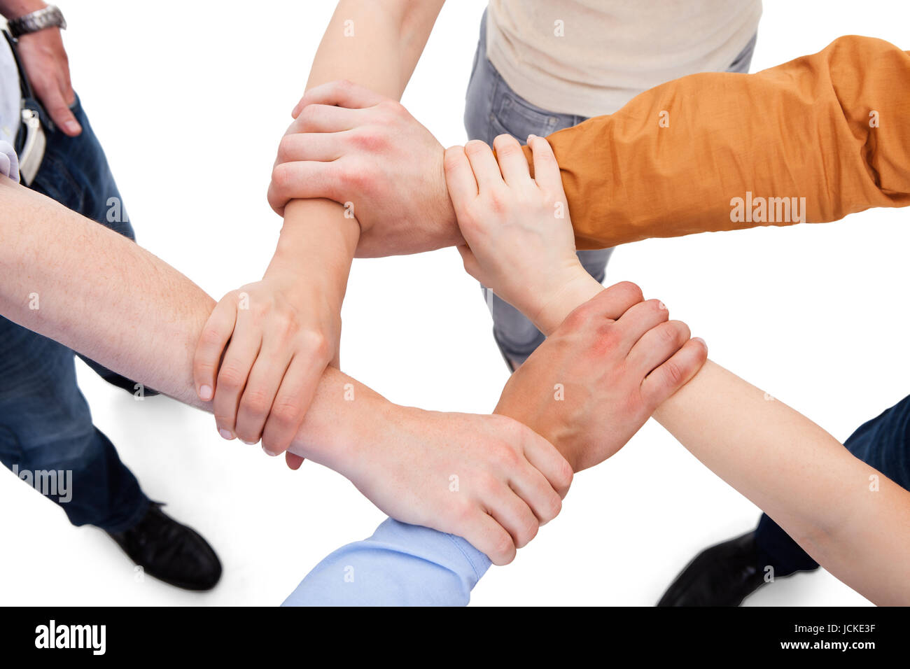 Cropped image of young friends linking hands in team over white ...