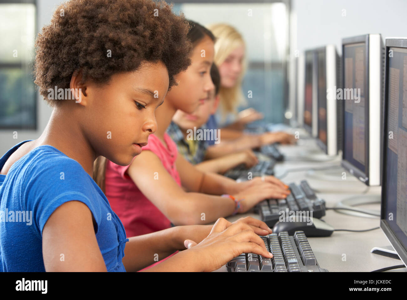 Elementary Students Working At Computers In Classroom Stock Photo - Alamy