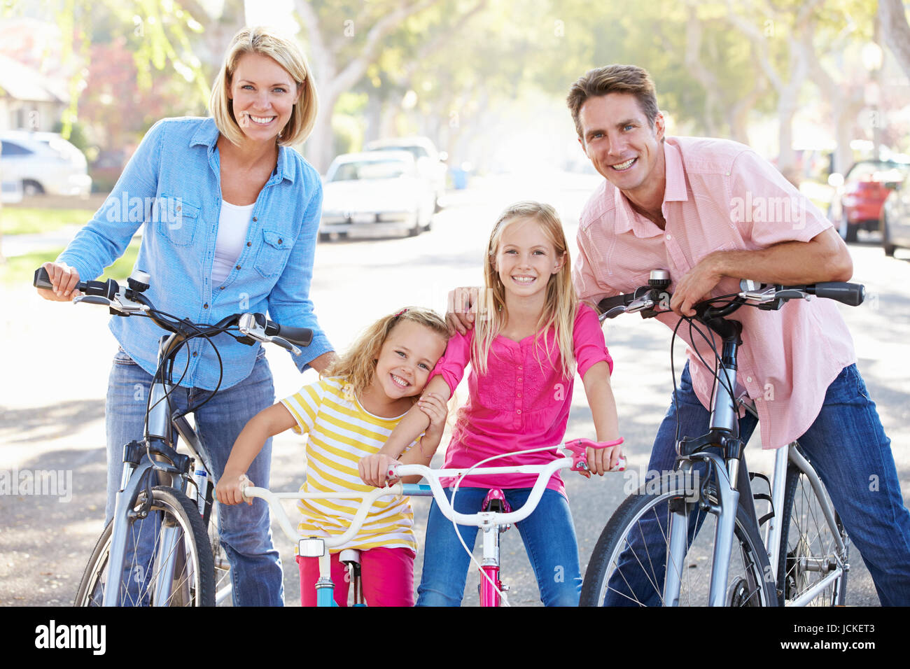Family Cycling On Suburban Street Stock Photo - Alamy