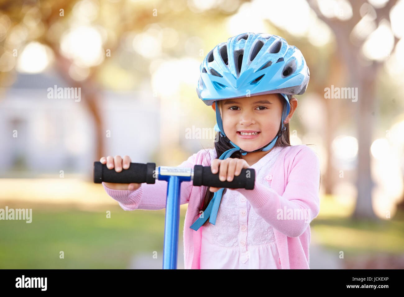 Girl Wearing Safety Helmet Riding Scooter Stock Photo - Alamy