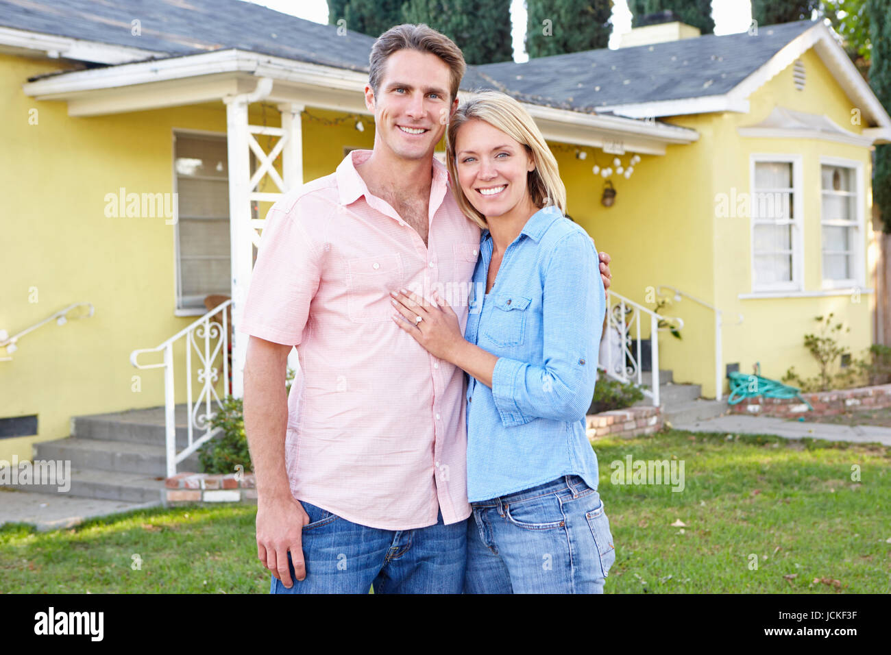 Couple Standing Outside Suburban Home Stock Photo - Alamy