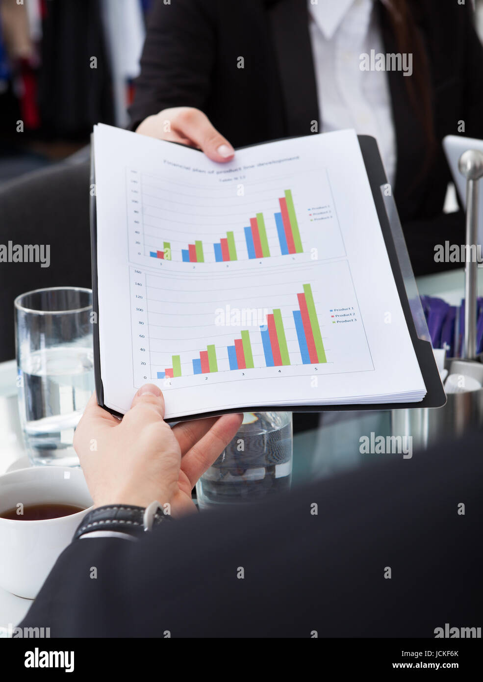 Cropped image of businesswoman giving progress chart to colleague at ...