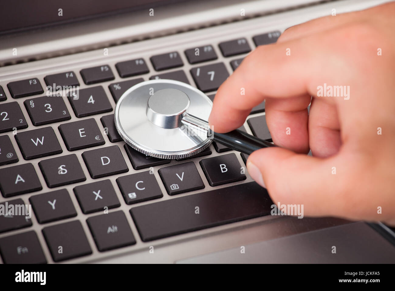 Closeup of man's hand examining laptop with stethoscope Stock Photo - Alamy