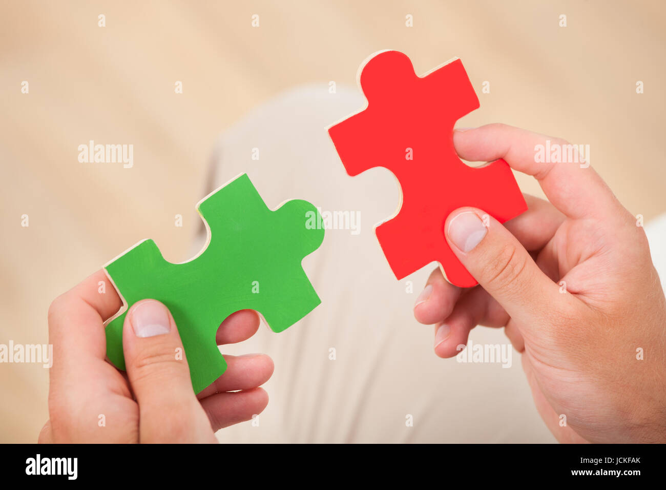 Cropped image of man joining puzzle pieces at home Stock Photo - Alamy