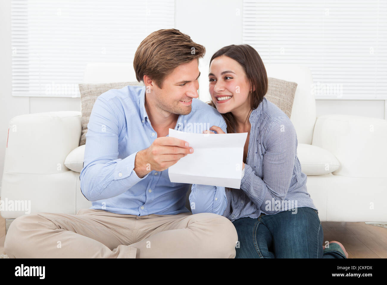 Happy couple reading letter together at home Stock Photo - Alamy