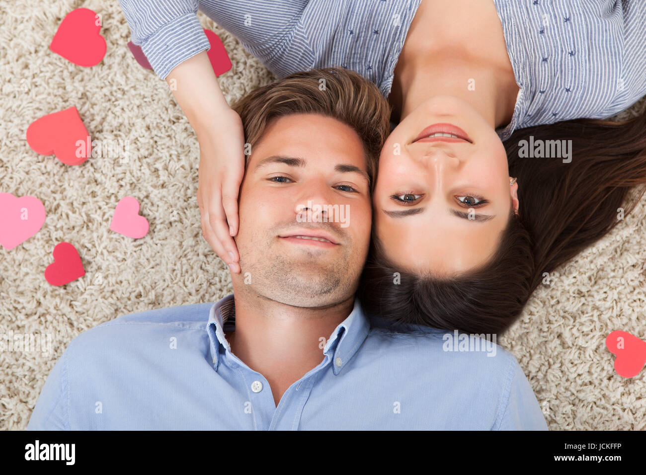 High angle portrait of loving couple lying on rug at home Stock Photo ...