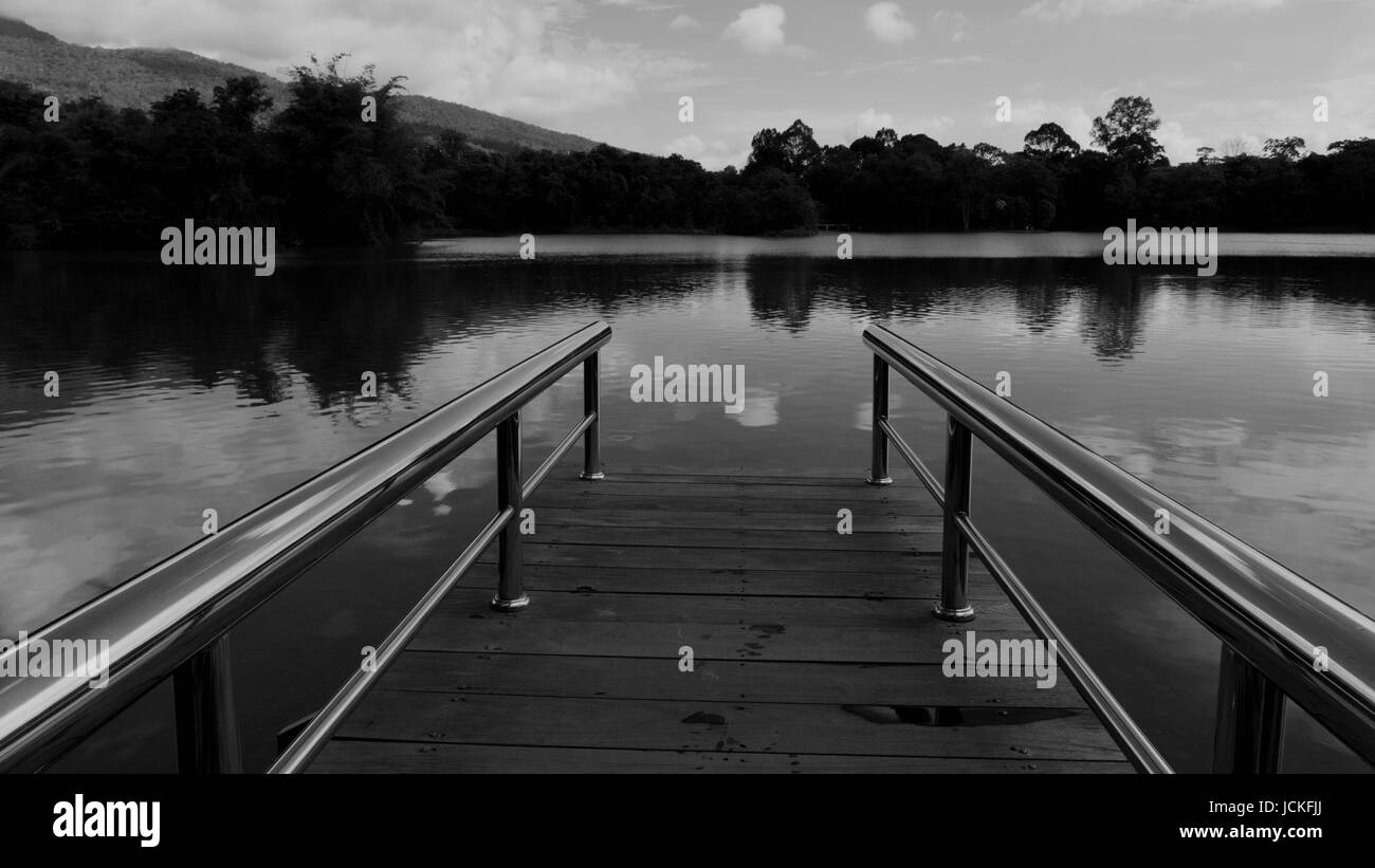 Perspective view of pier and landscape of forest, lake and mountains in ...