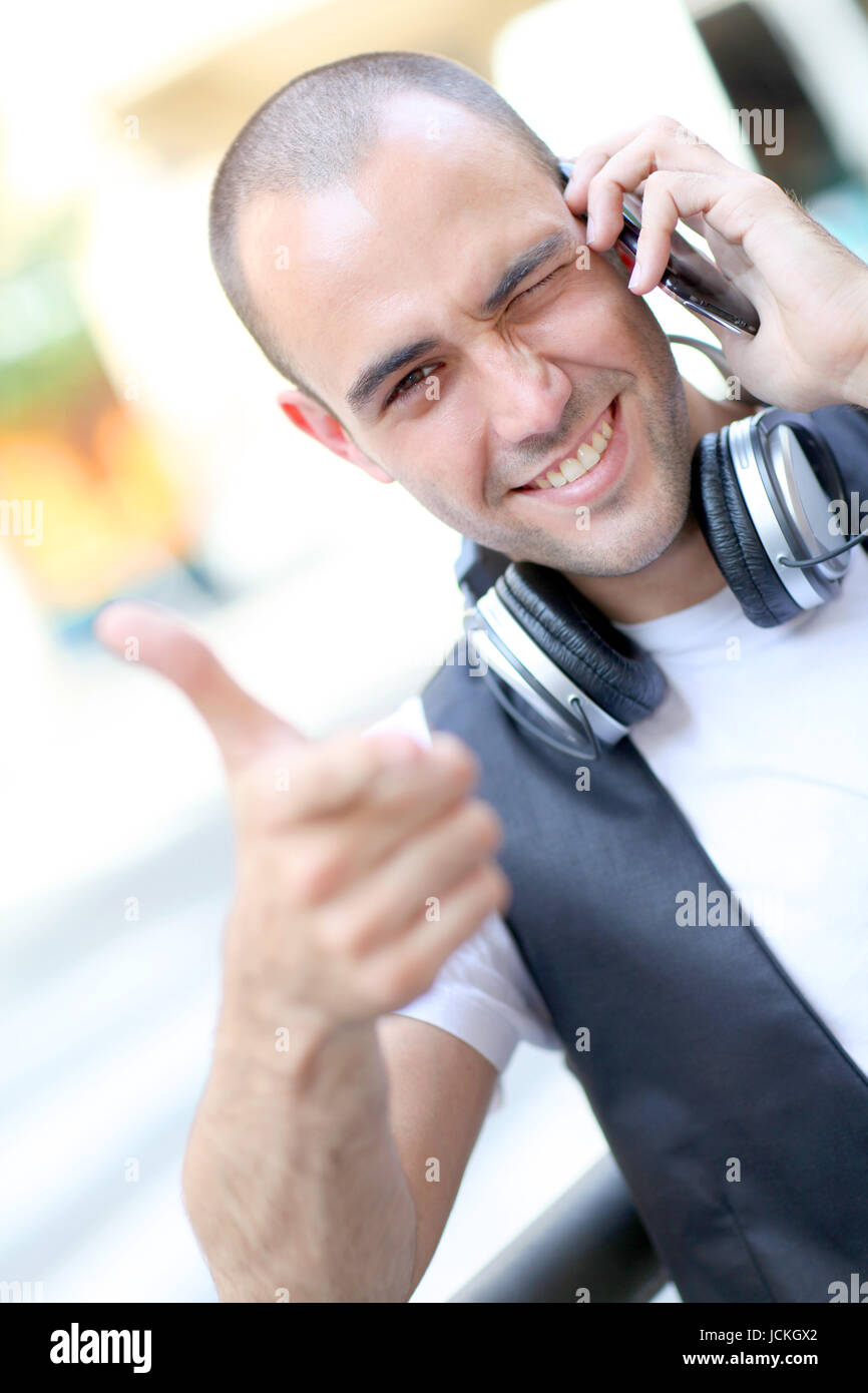 Smiling man listening to music in the street Stock Photo - Alamy