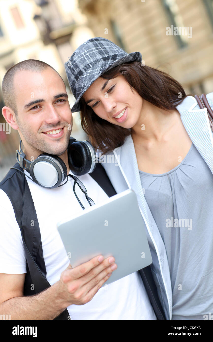 Young couple using electronic tablet in town Stock Photo - Alamy