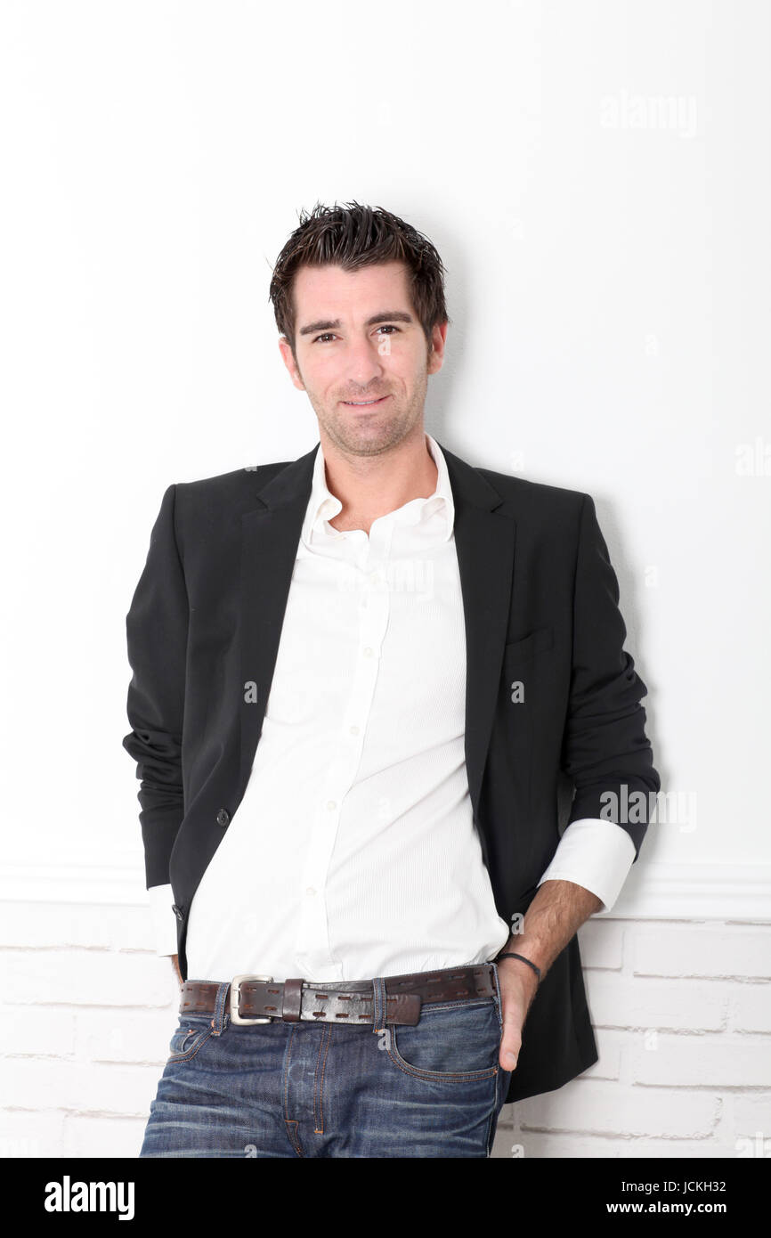Handsome guy leaning on white wall Stock Photo - Alamy