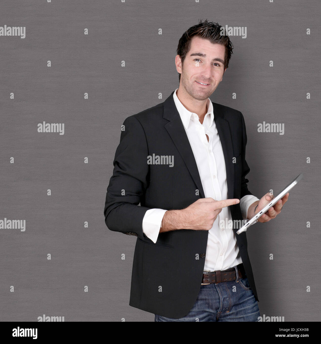 Smiling man standing on dark background Stock Photo - Alamy