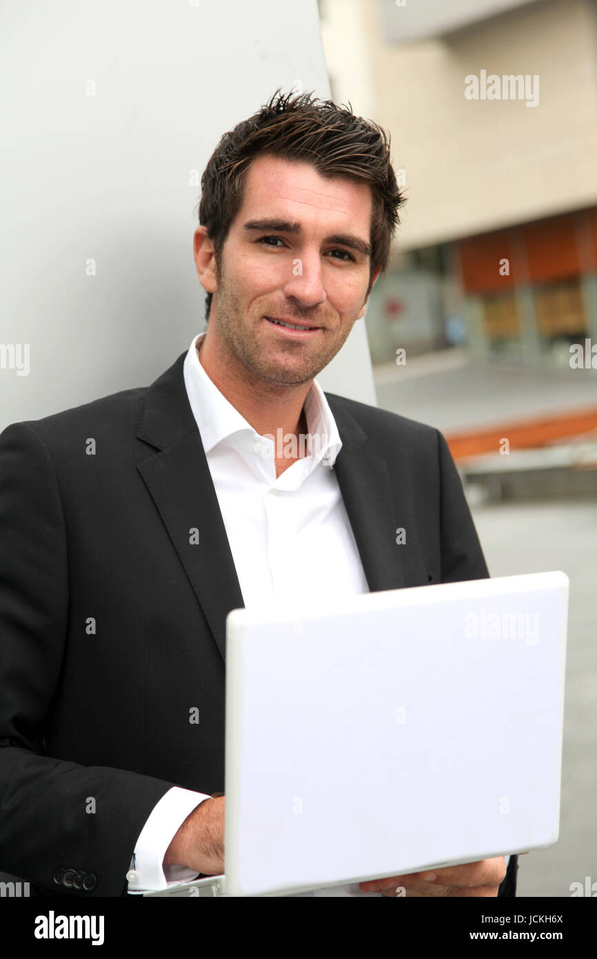 Salesman working outside on laptop computer Stock Photo - Alamy
