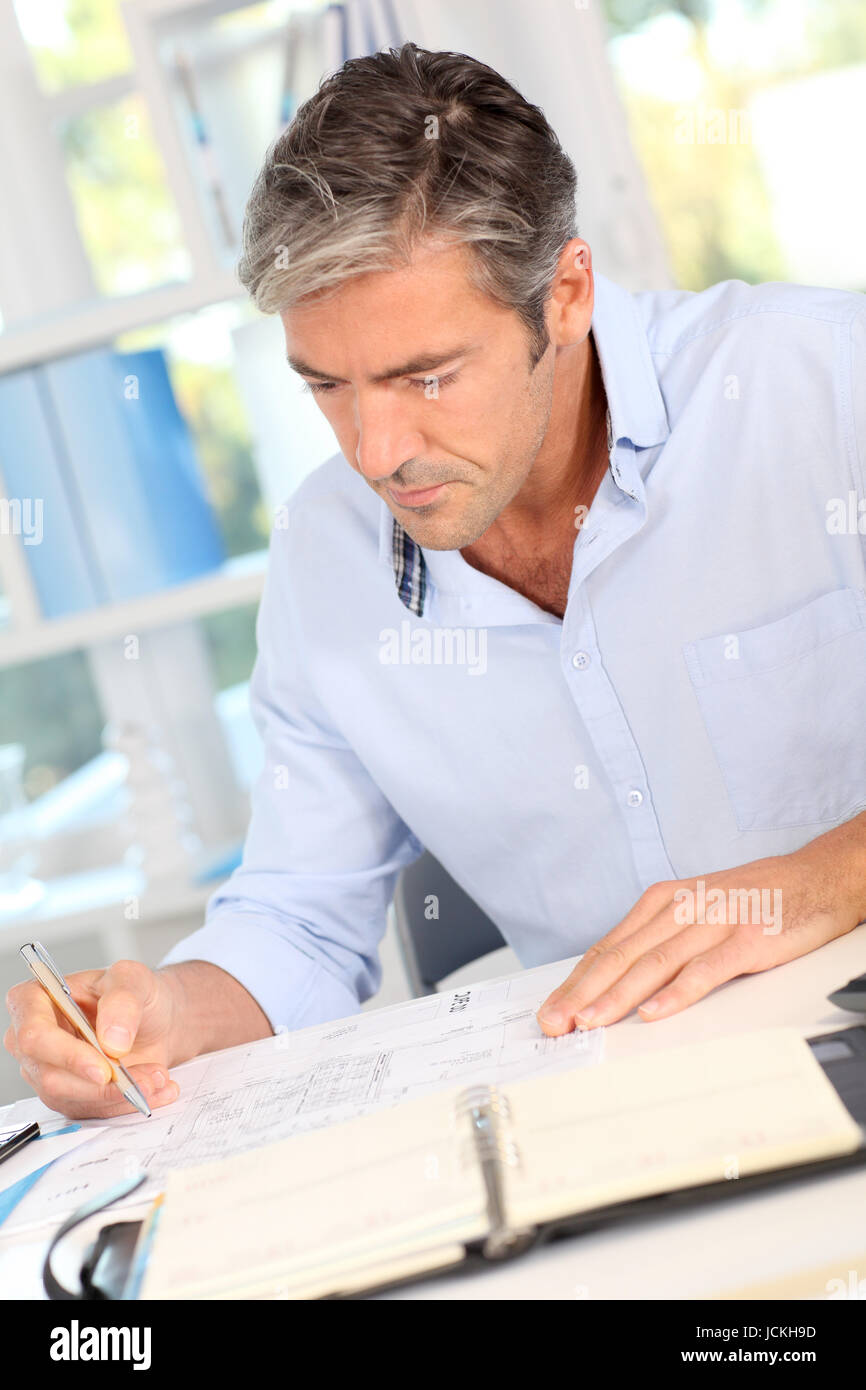 Handsome office worker writing notes on agenda Stock Photo - Alamy