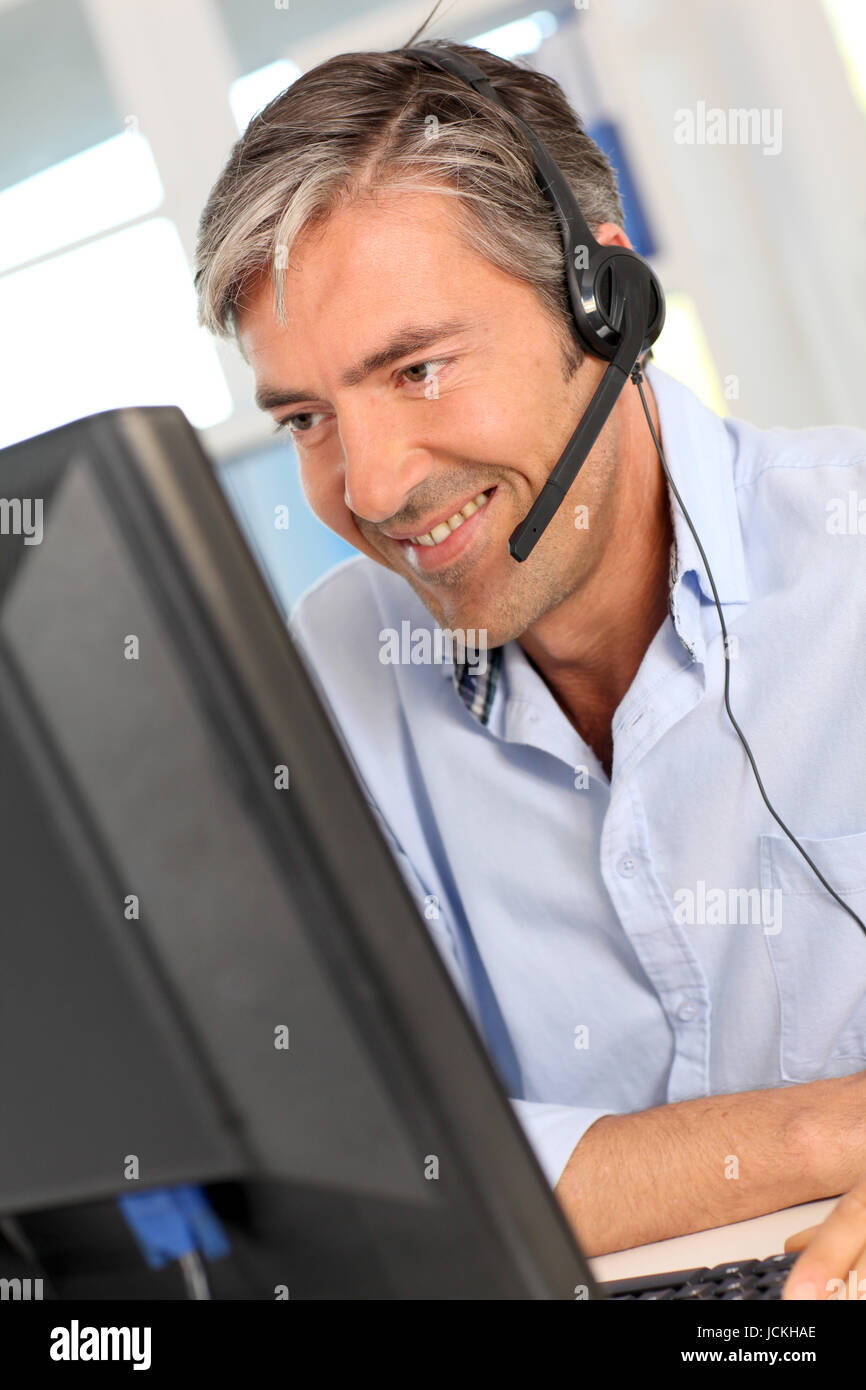 Customer service employee with headphones Stock Photo - Alamy