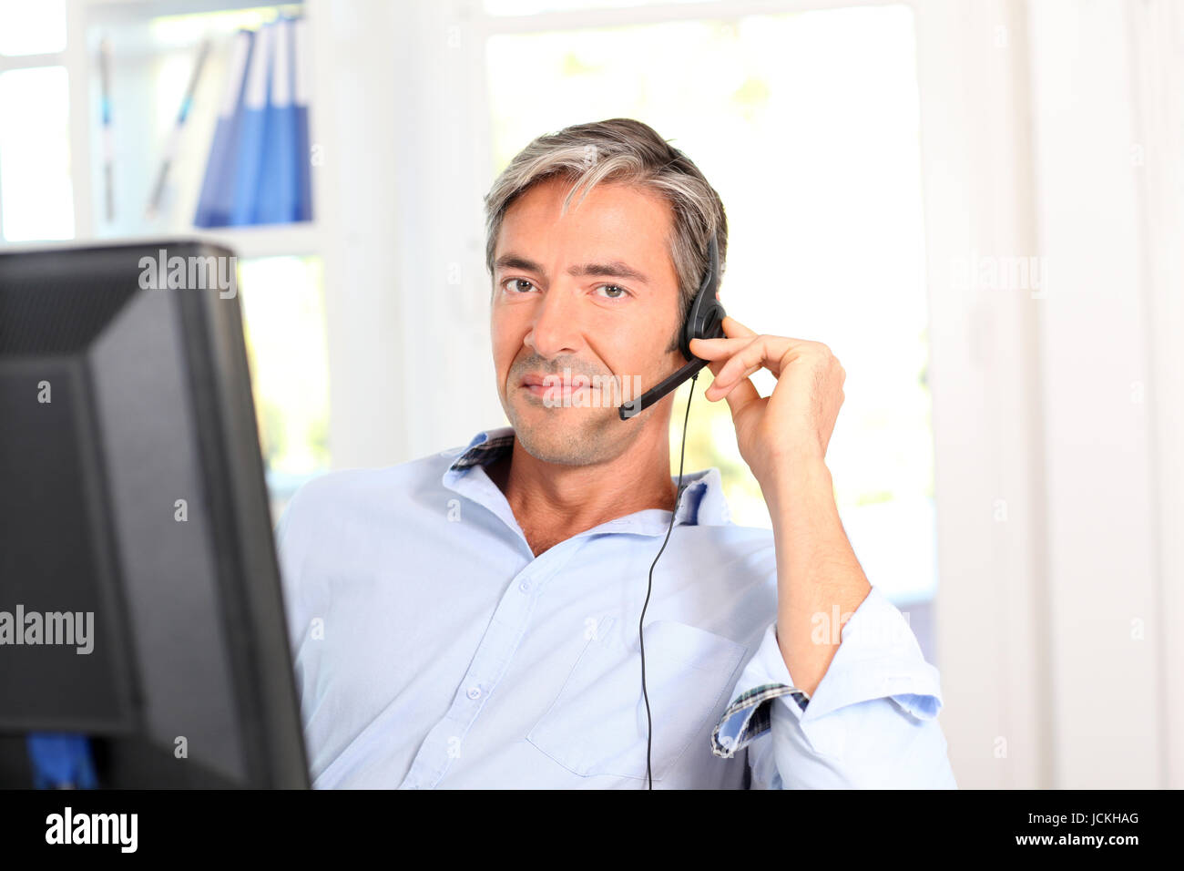 Customer service employee with headphones Stock Photo - Alamy