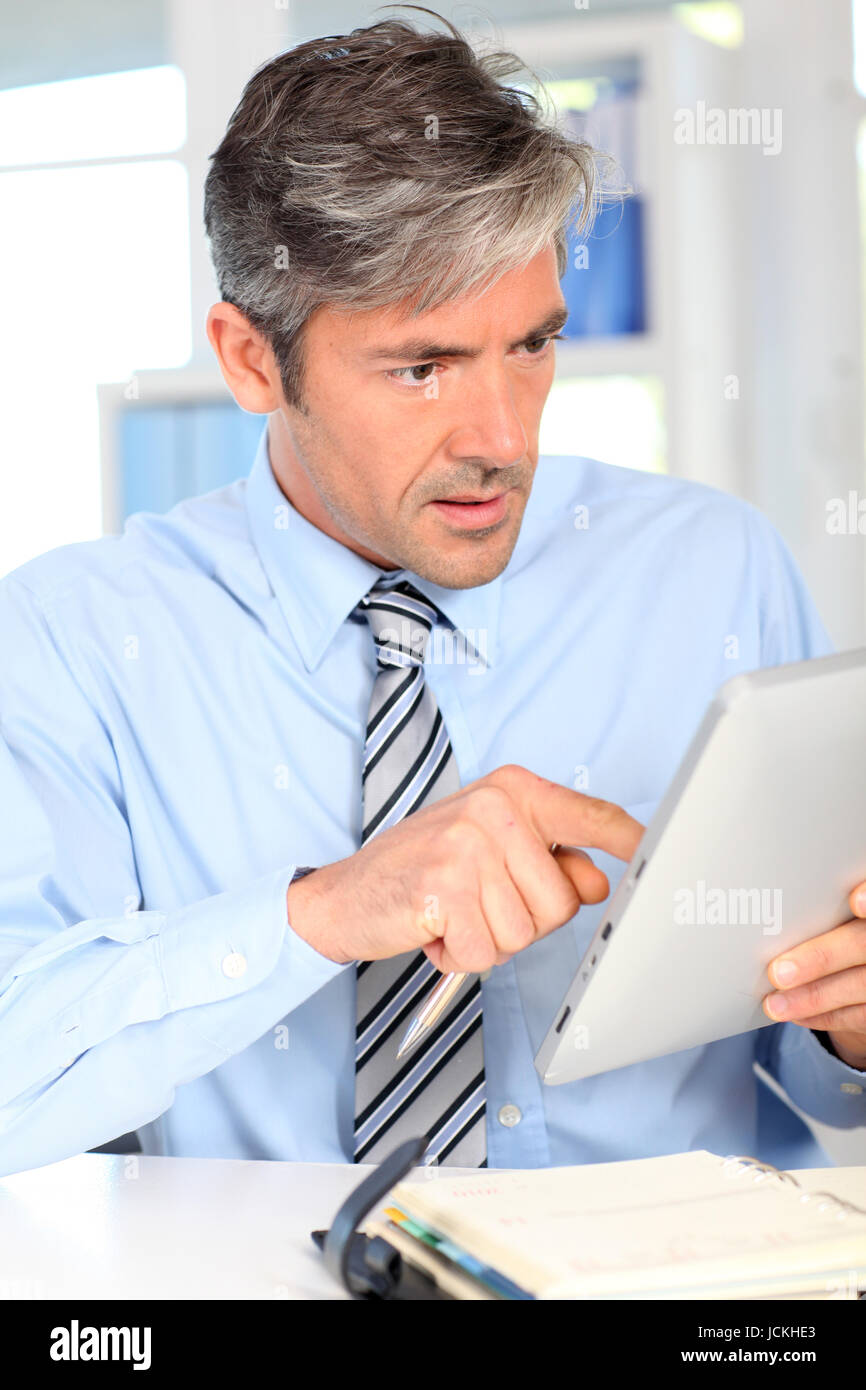 Manager in office using electronic tablet Stock Photo - Alamy