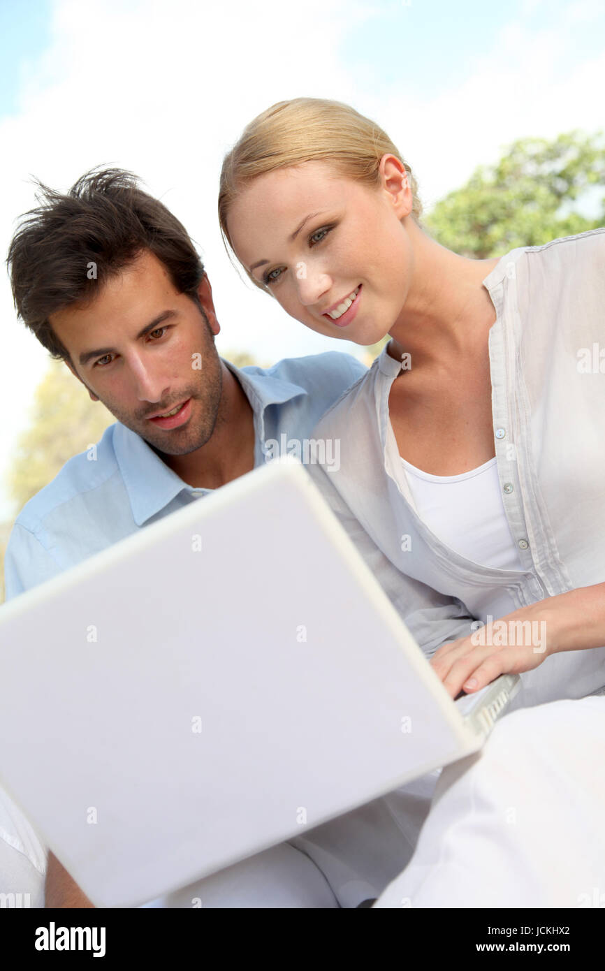 Young couple connected on internet sitting in longchairs Stock Photo ...