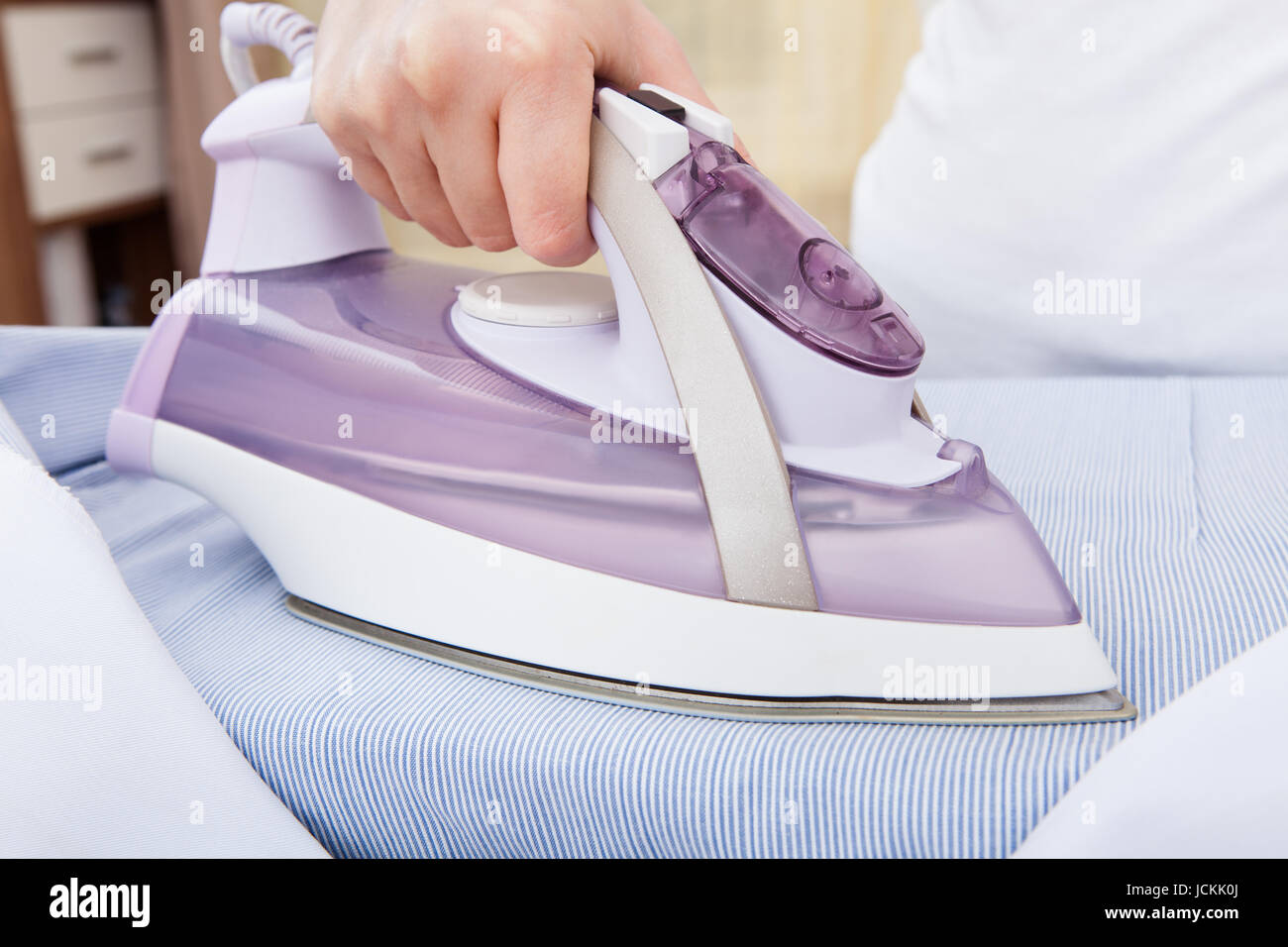 Close-up Of Woman's Hand Ironing Clothes On Ironing Board Stock Photo ...
