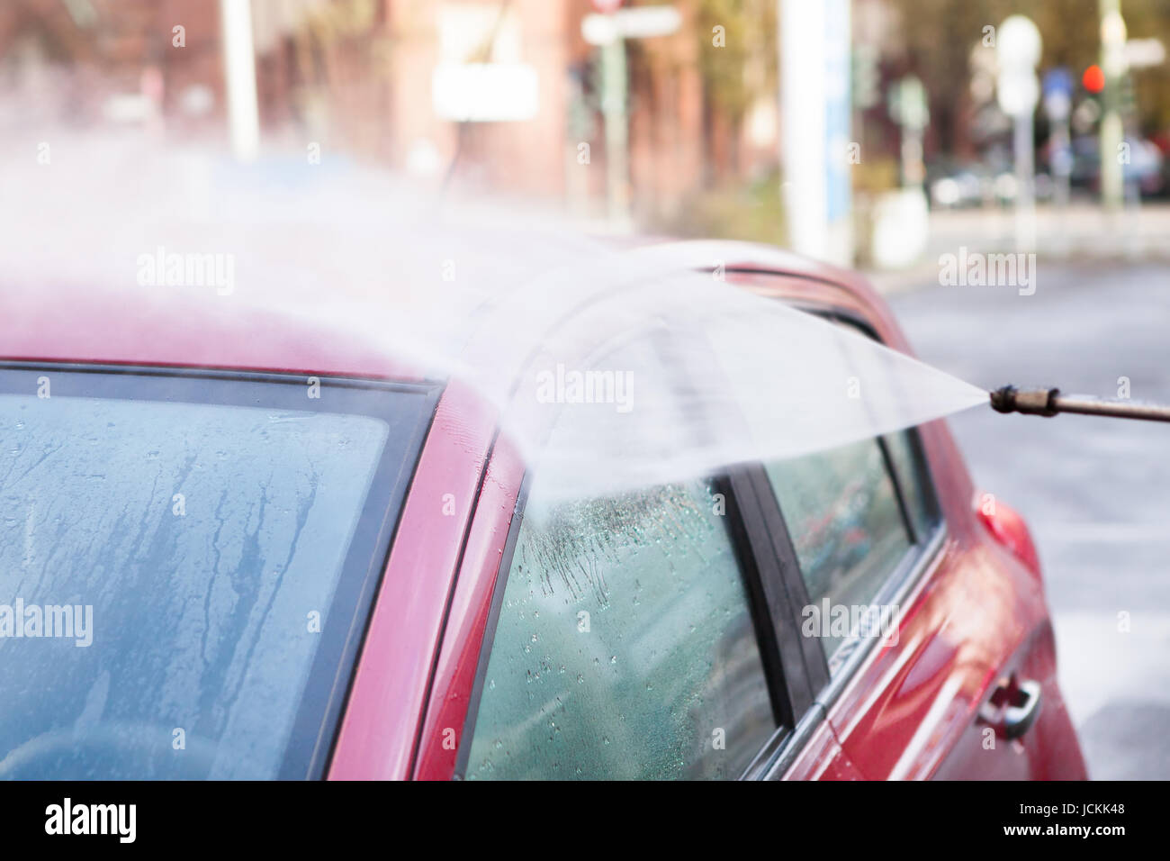 Hose Spraying Water On Red Stylish Car Stock Photo - Alamy