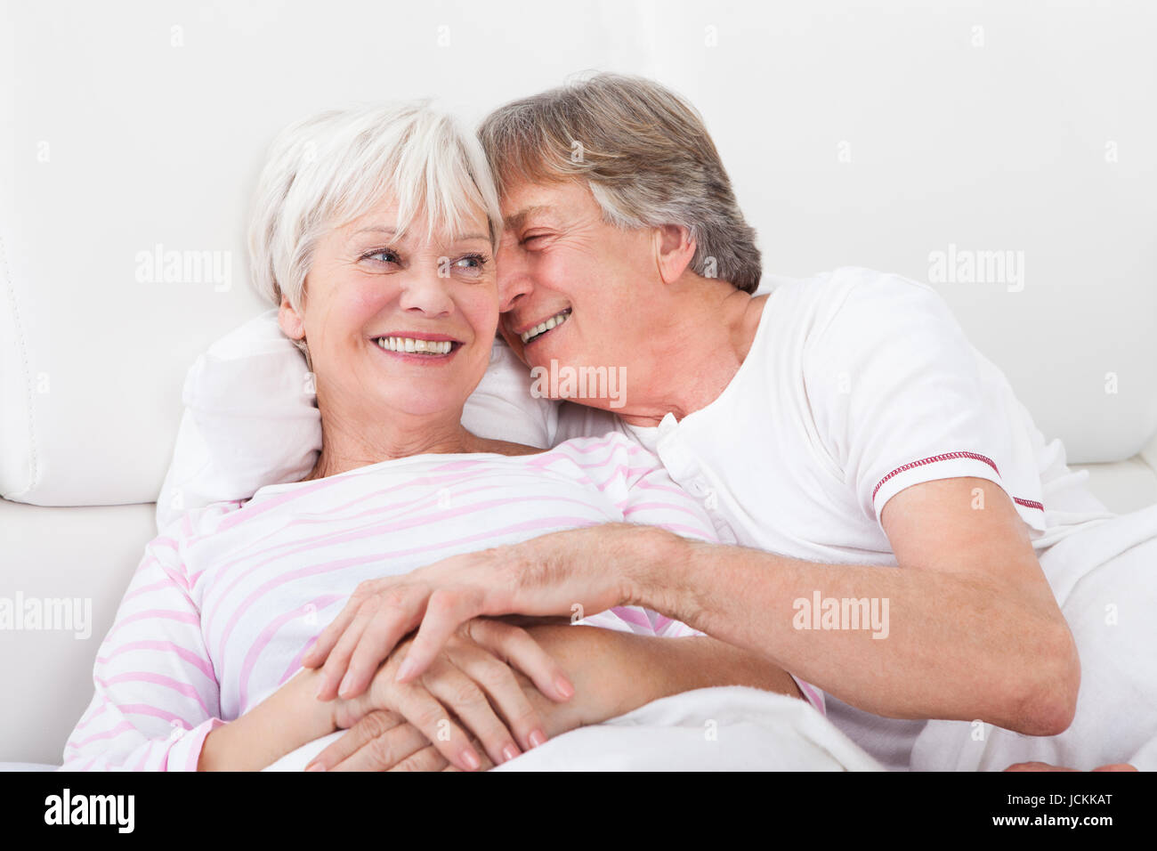 Senior couple cuddling bed hi-res stock photography and images - Alamy