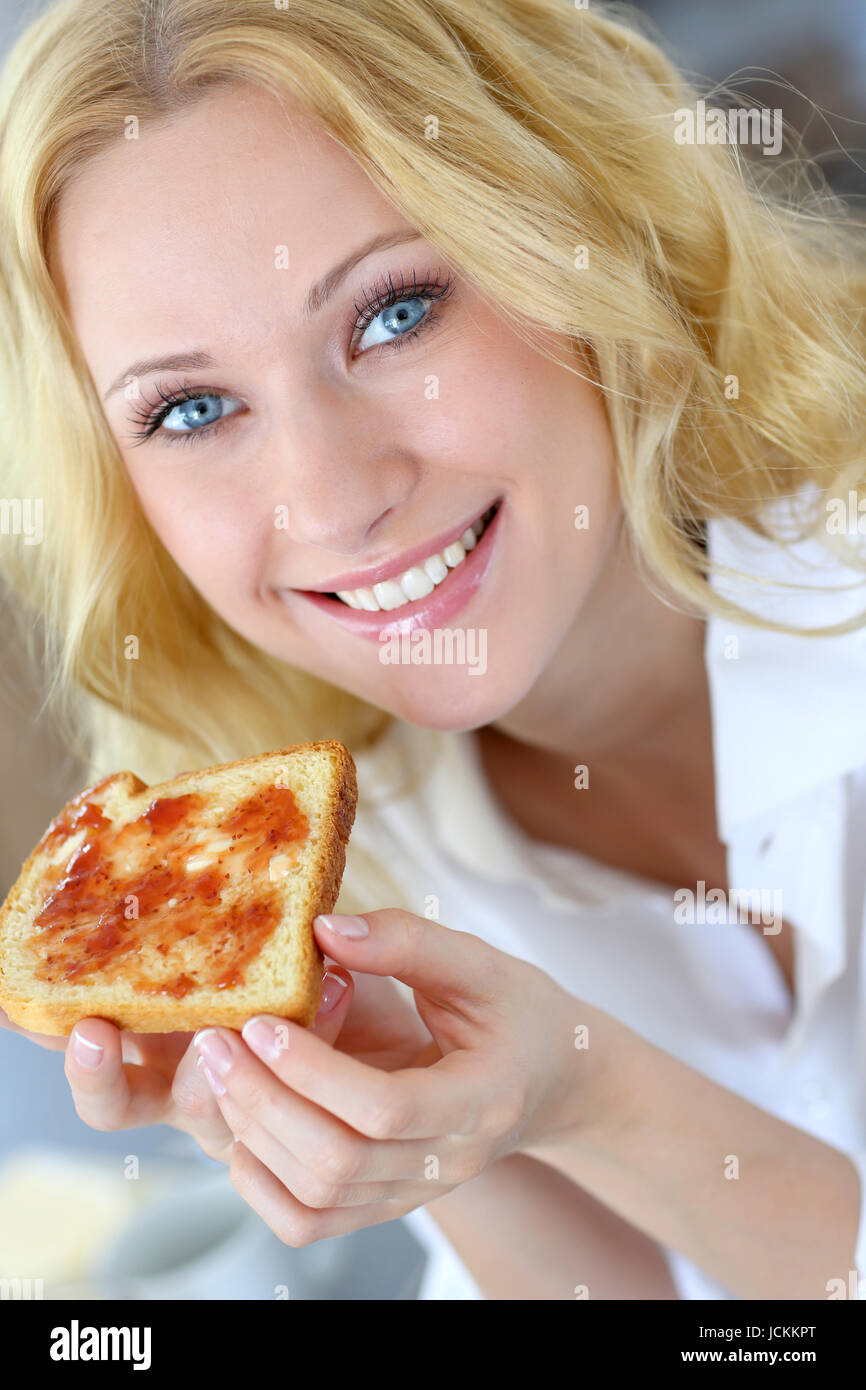 Beautiful girl eating toasted bread for breakfast Stock Photo - Alamy