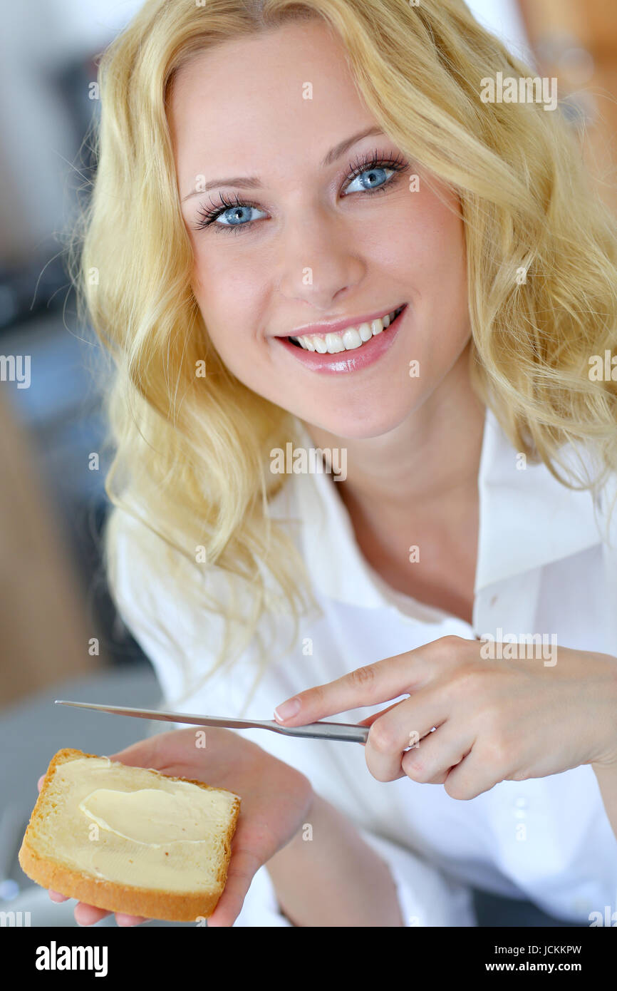 Beautiful girl eating toasted bread for breakfast Stock Photo - Alamy