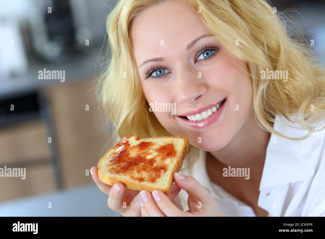 Beautiful girl eating toasted bread for breakfast Stock Photo - Alamy