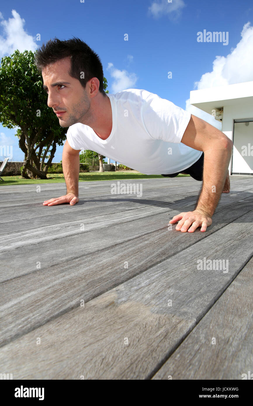 Young man doing pushups on pool deck Stock Photo - Alamy