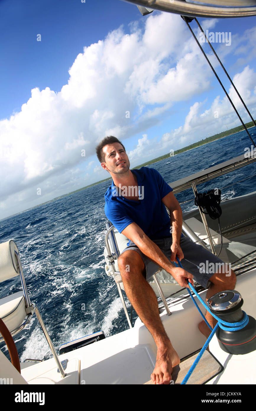 Sailot pulling on sail rope during navigation Stock Photo - Alamy