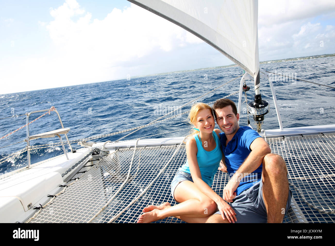 Couple relaxing on catamaran net looking at the sea Stock Photo - Alamy
