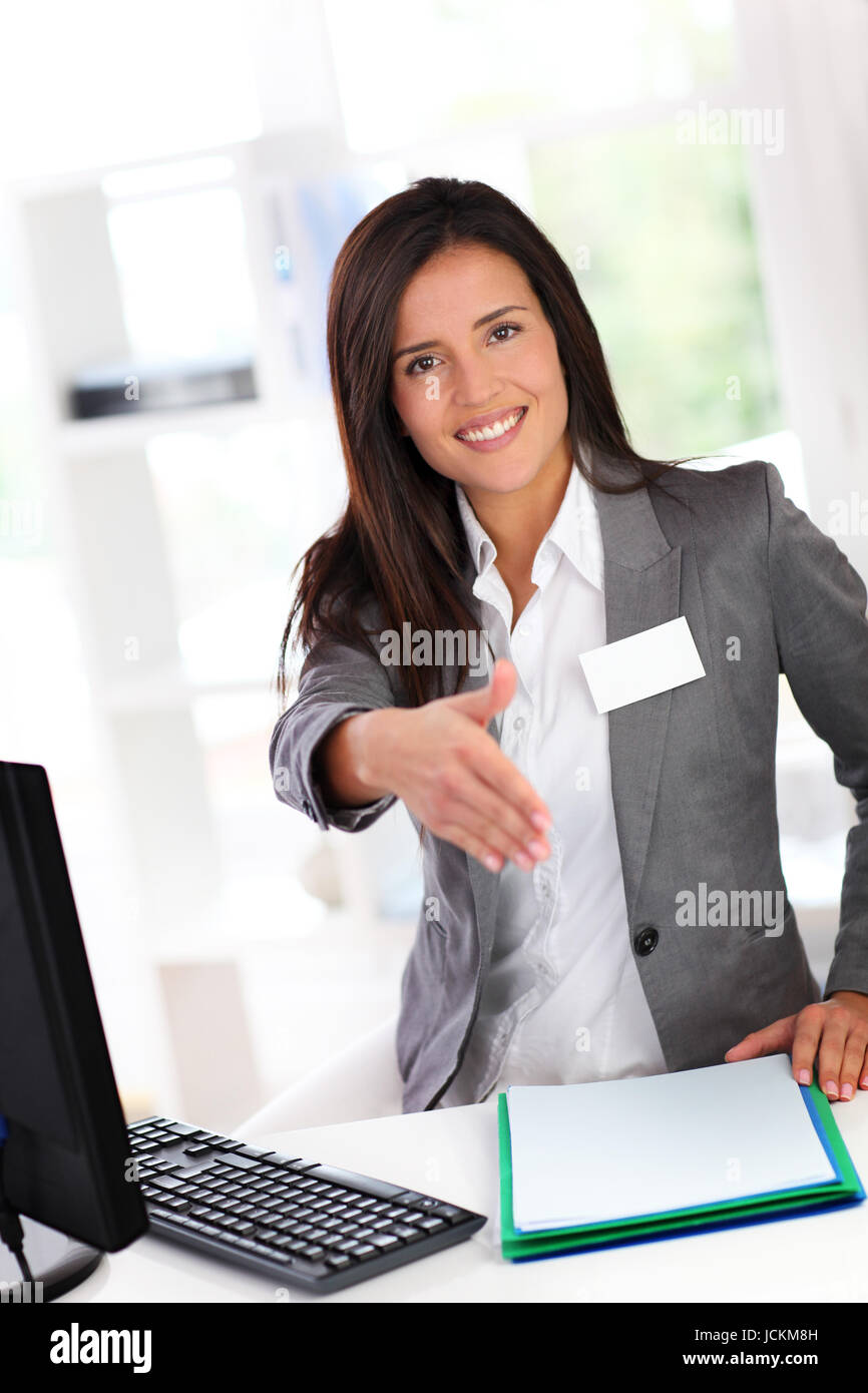 Portrait of beautiful smiling hostess giving handshake Stock Photo - Alamy