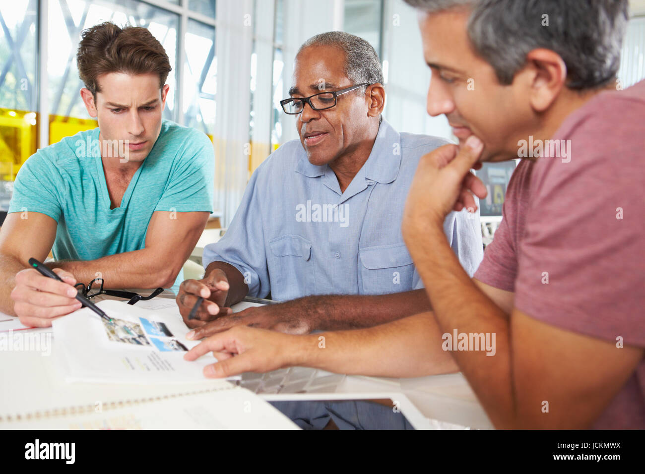 Group Of Men Meeting In Creative Office Stock Photo - Alamy