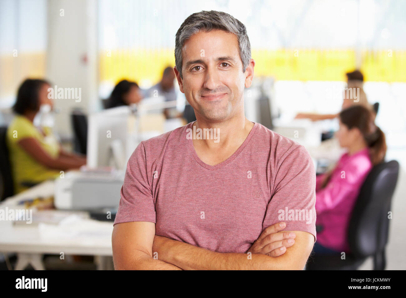 Portrait Of Man Standing In Busy Creative Office Stock Photo - Alamy